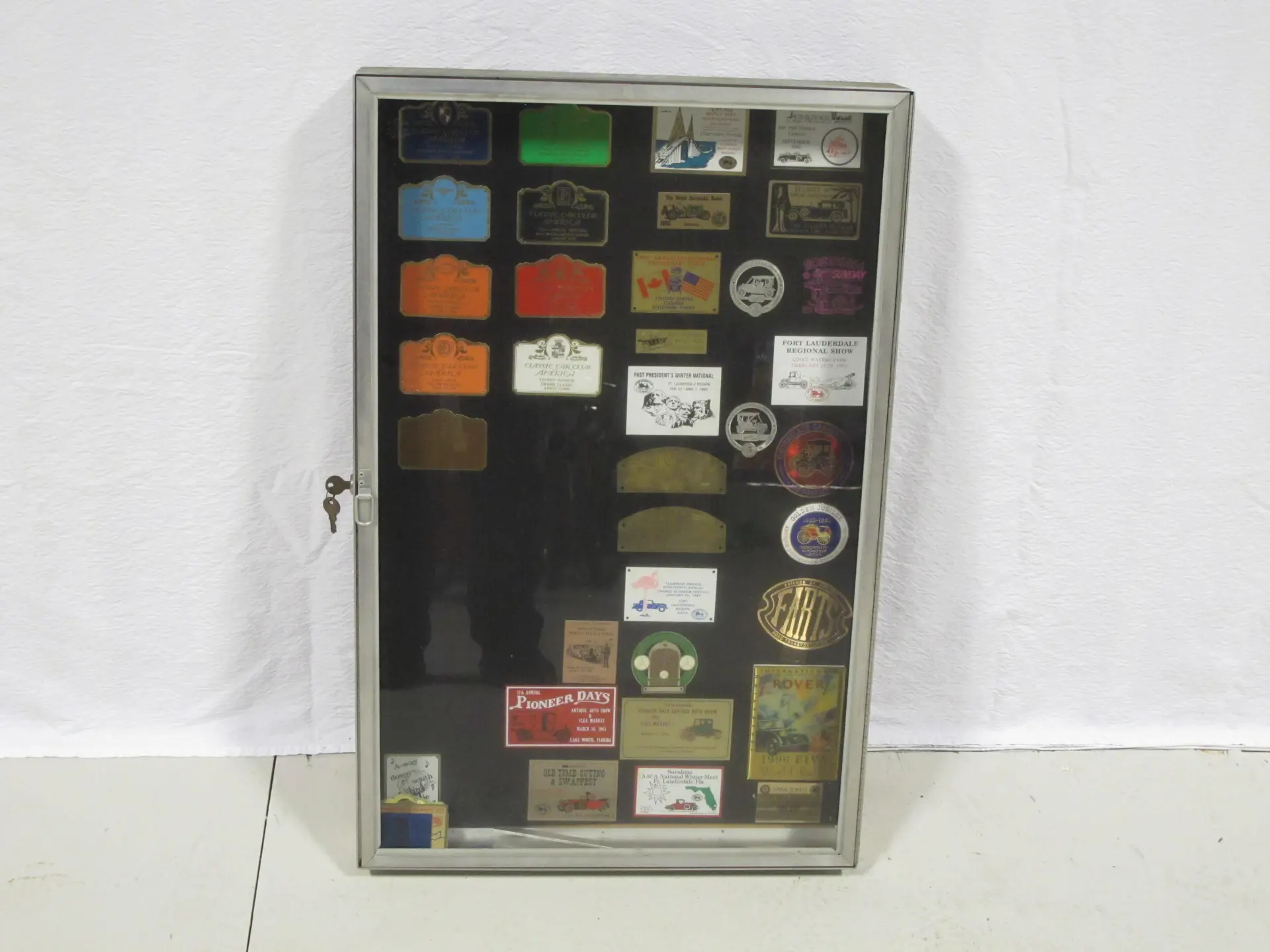 Display case full of dash plaques B | Fort Lauderdale 2015 | RM Sotheby's