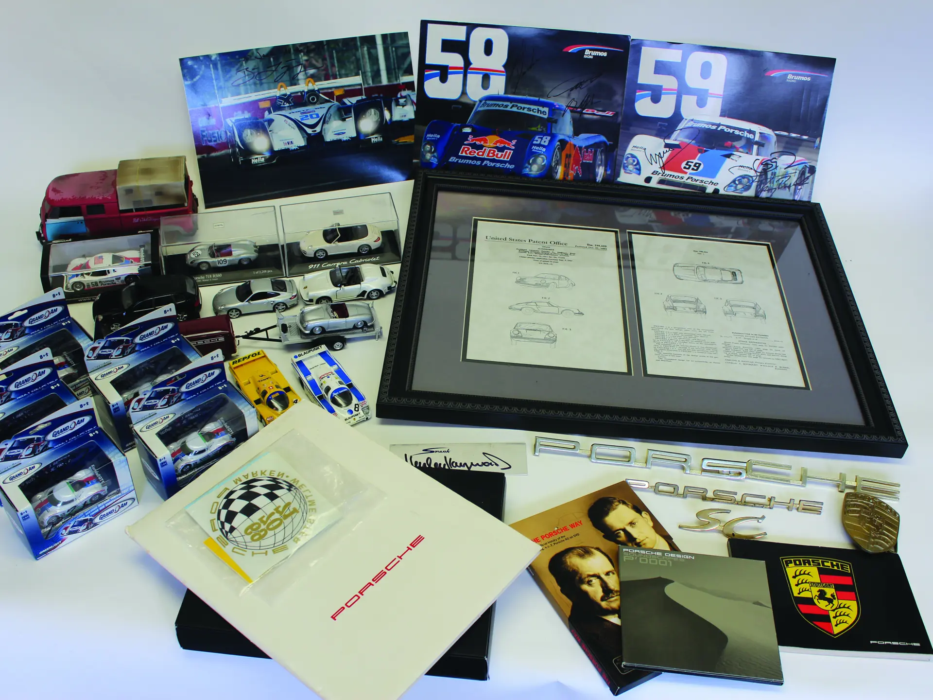 A mixed grouping of Porsche collectibles and driver signed items ...